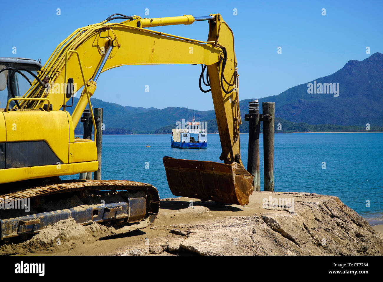 excavator on the beach moving sand and repair erosion after tide damage ...