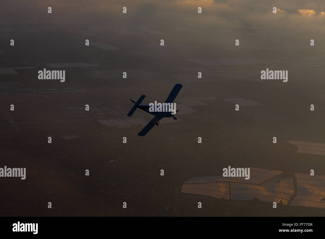 Small single engine airplane flying in the gorgeous sunset sky through ...