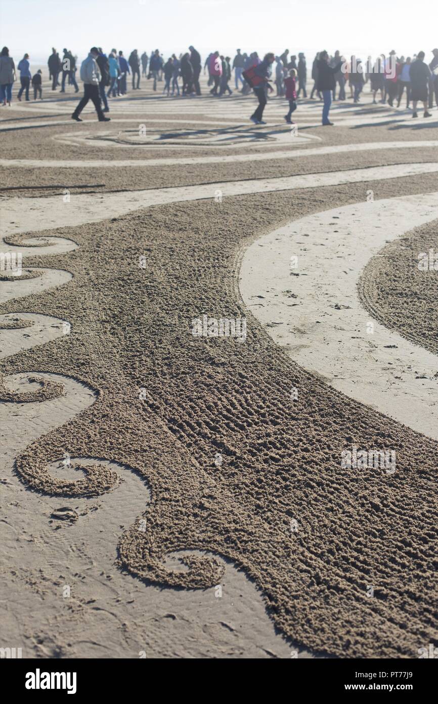 People walking a large sand labyrinth created by Denny Dyke, at Heceta ...