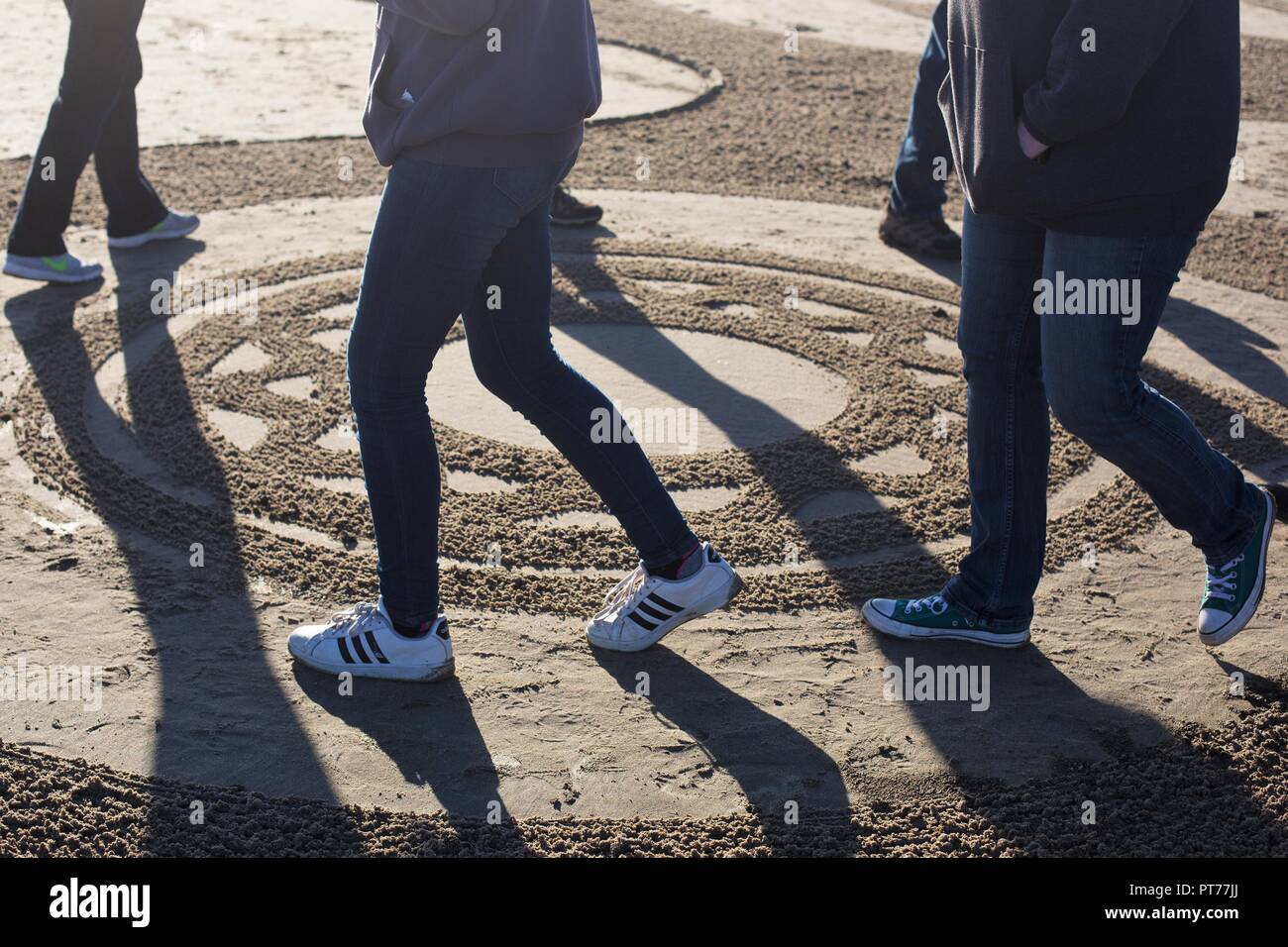 Close up of people walking a large sand labyrinth created by Denny Dyke ...