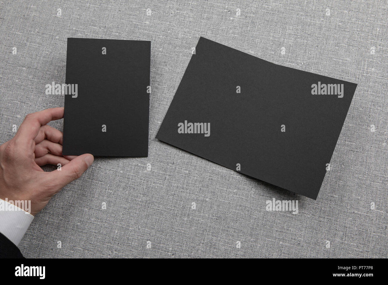 Mens hands holding empty black booklet on gray background. View from ...