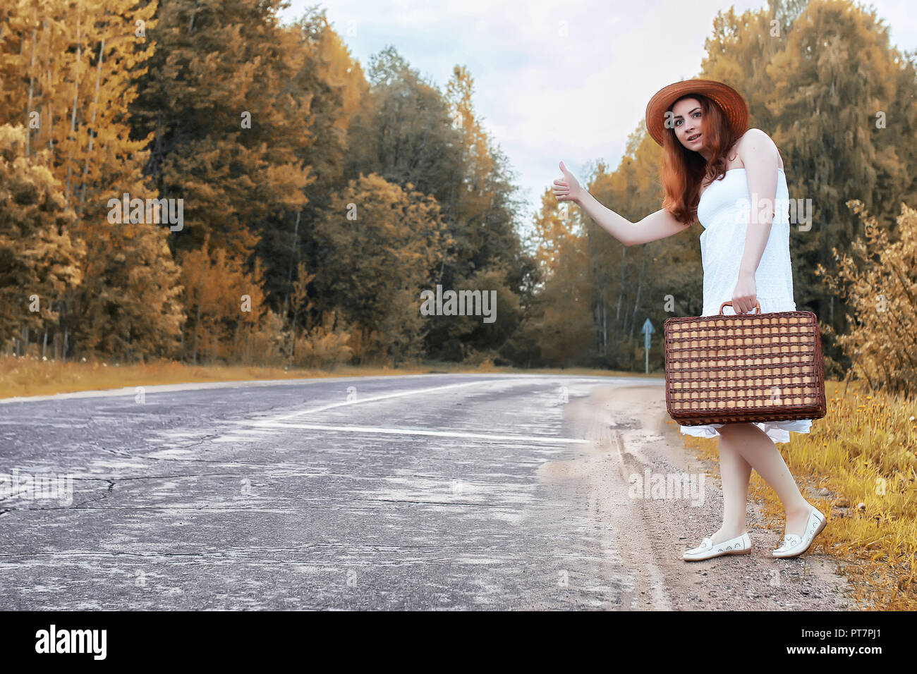 autumn park girl in white sundress and a wicker suitcase walking Stock ...