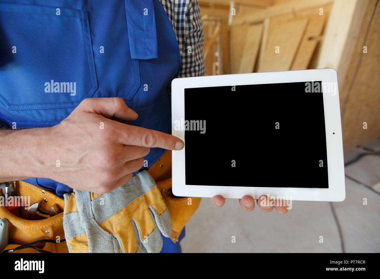 Construction worker pointing at digital tablet at construction site ...