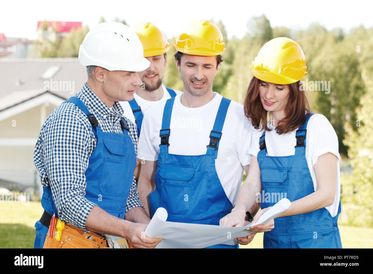 Construction workers with blueprint , teamwork concept Stock Photo - Alamy