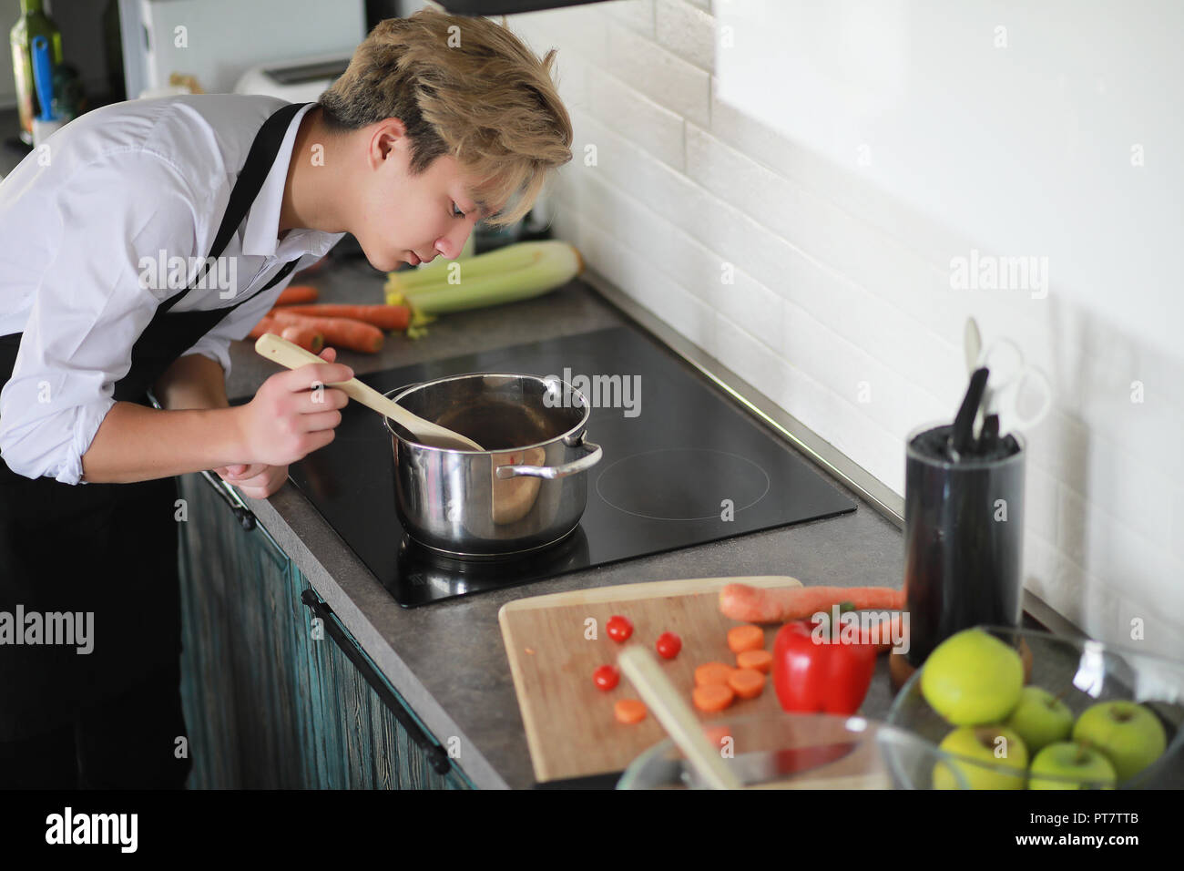 Asian cook in the kitchen prepares food in a cook suit Stock Photo - Alamy