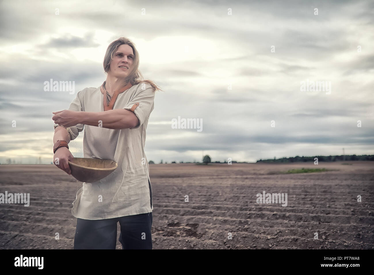 A young peasant sows the field with grain Stock Photo - Alamy
