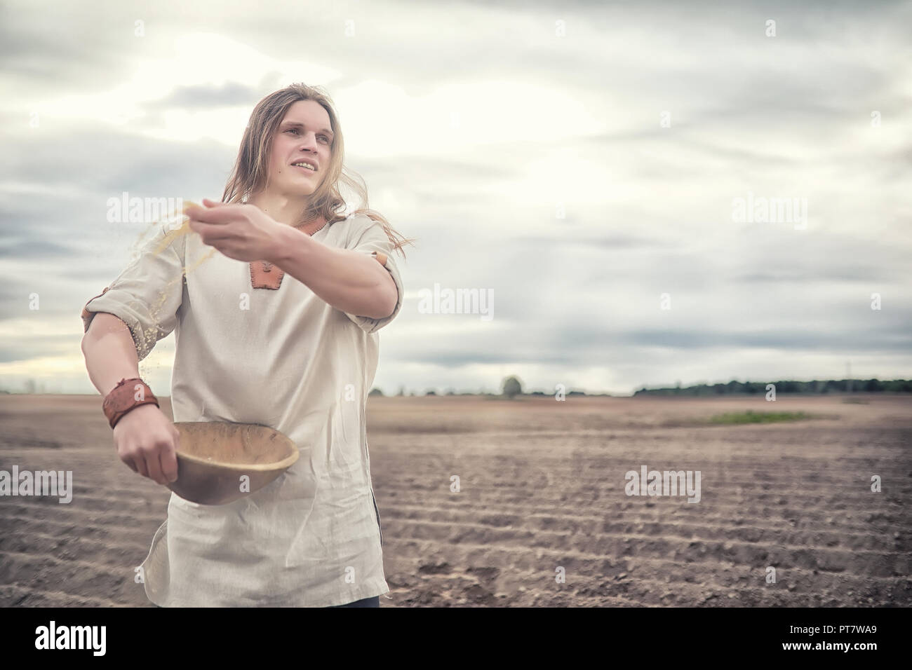 A young peasant sows the field with grain Stock Photo - Alamy
