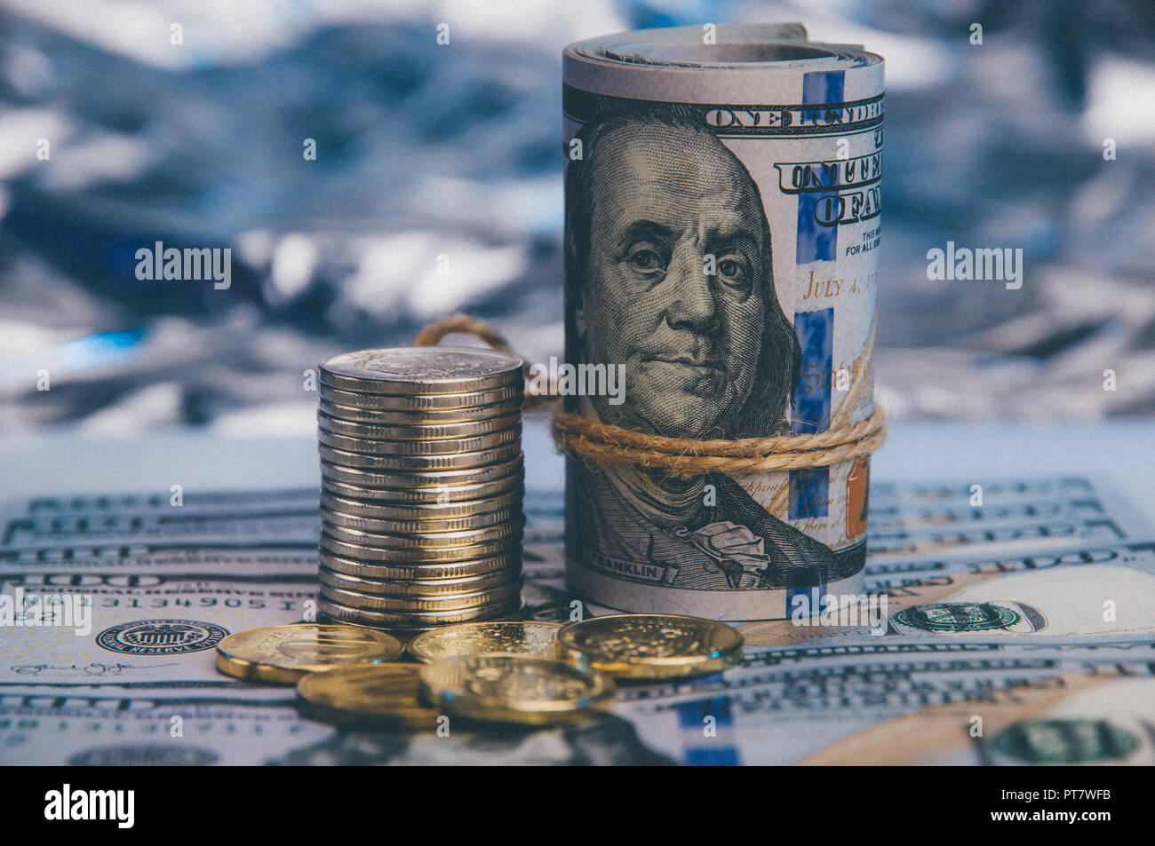 Against the blue backdrop of a hundred dollar bills spread out, a ...