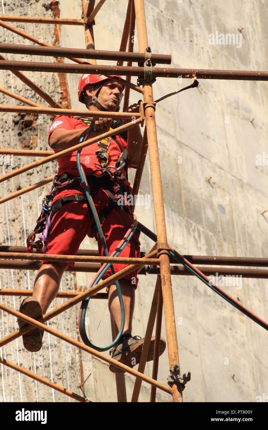 Construction workers working from scaffolding high above ground using ...