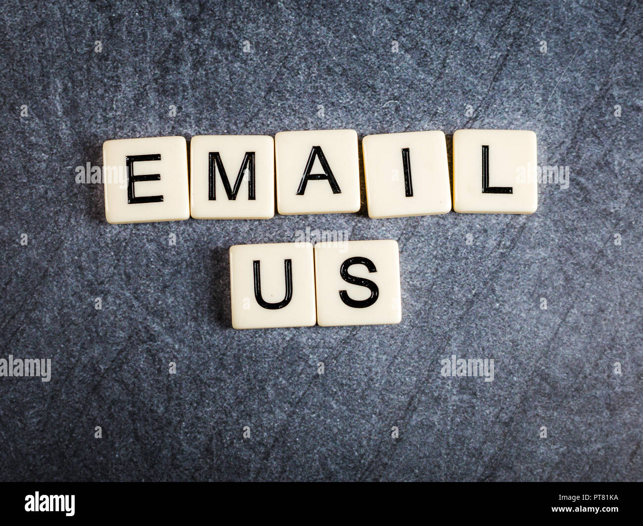 Letter tiles on black slate background spelling Email Us Stock Photo ...