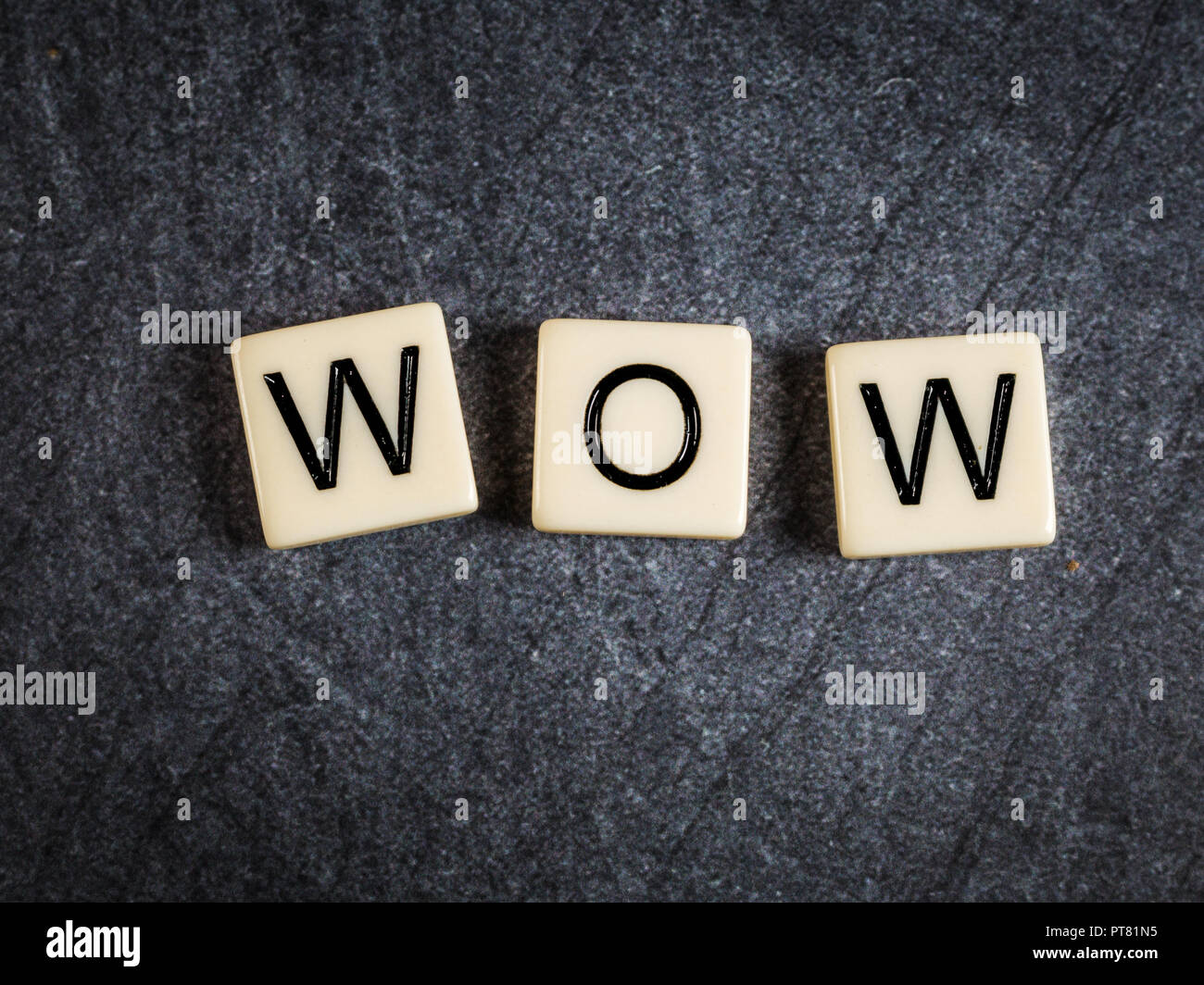 Letter tiles on black slate background spelling Wow Stock Photo - Alamy