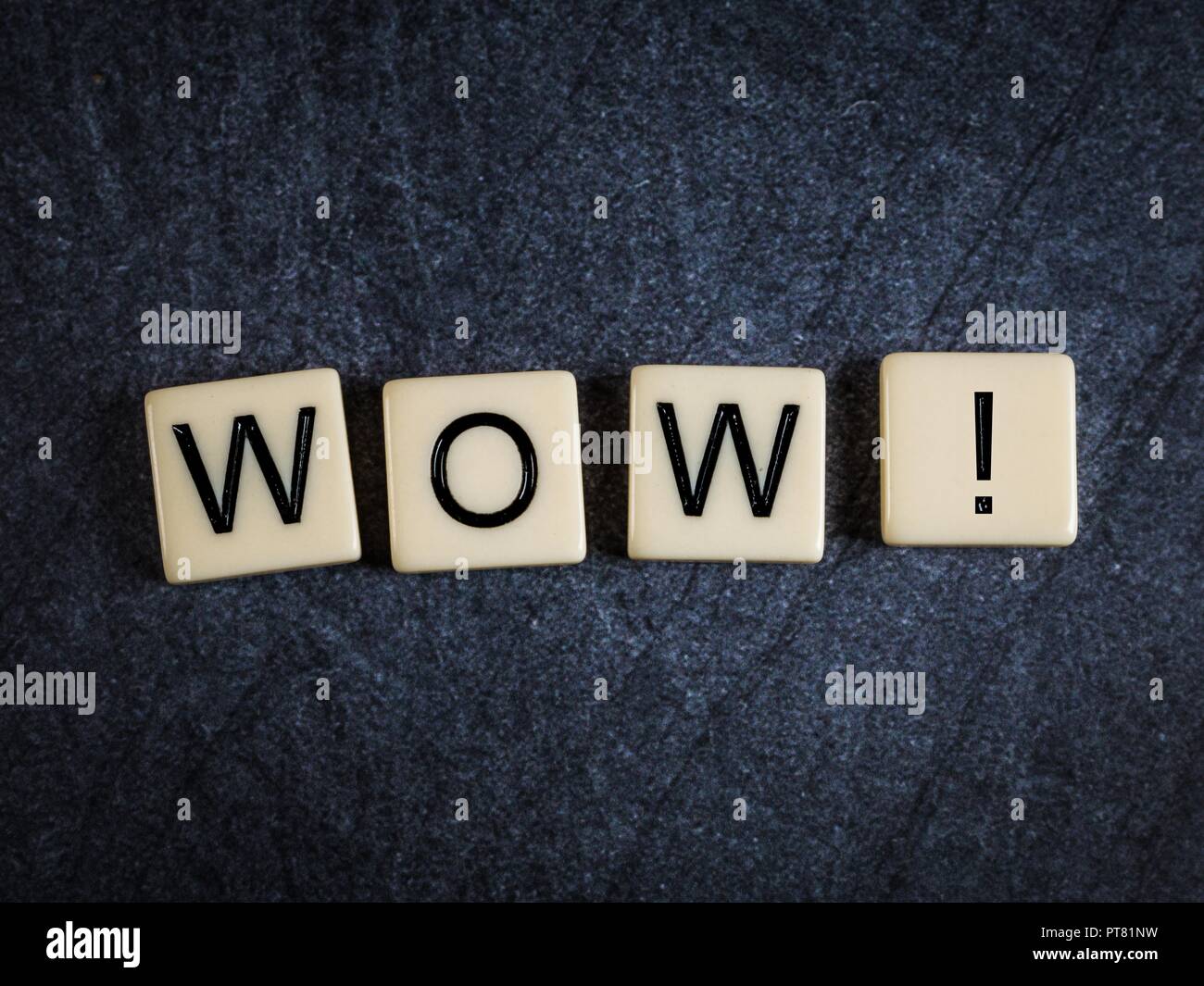 Letter tiles on black slate background spelling Wow! Stock Photo - Alamy