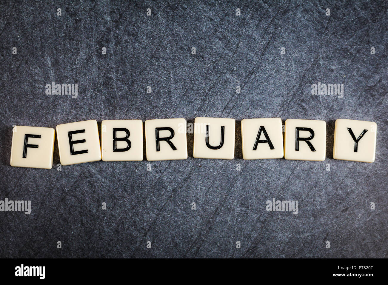 Letter tiles on black slate background spelling February Stock Photo ...