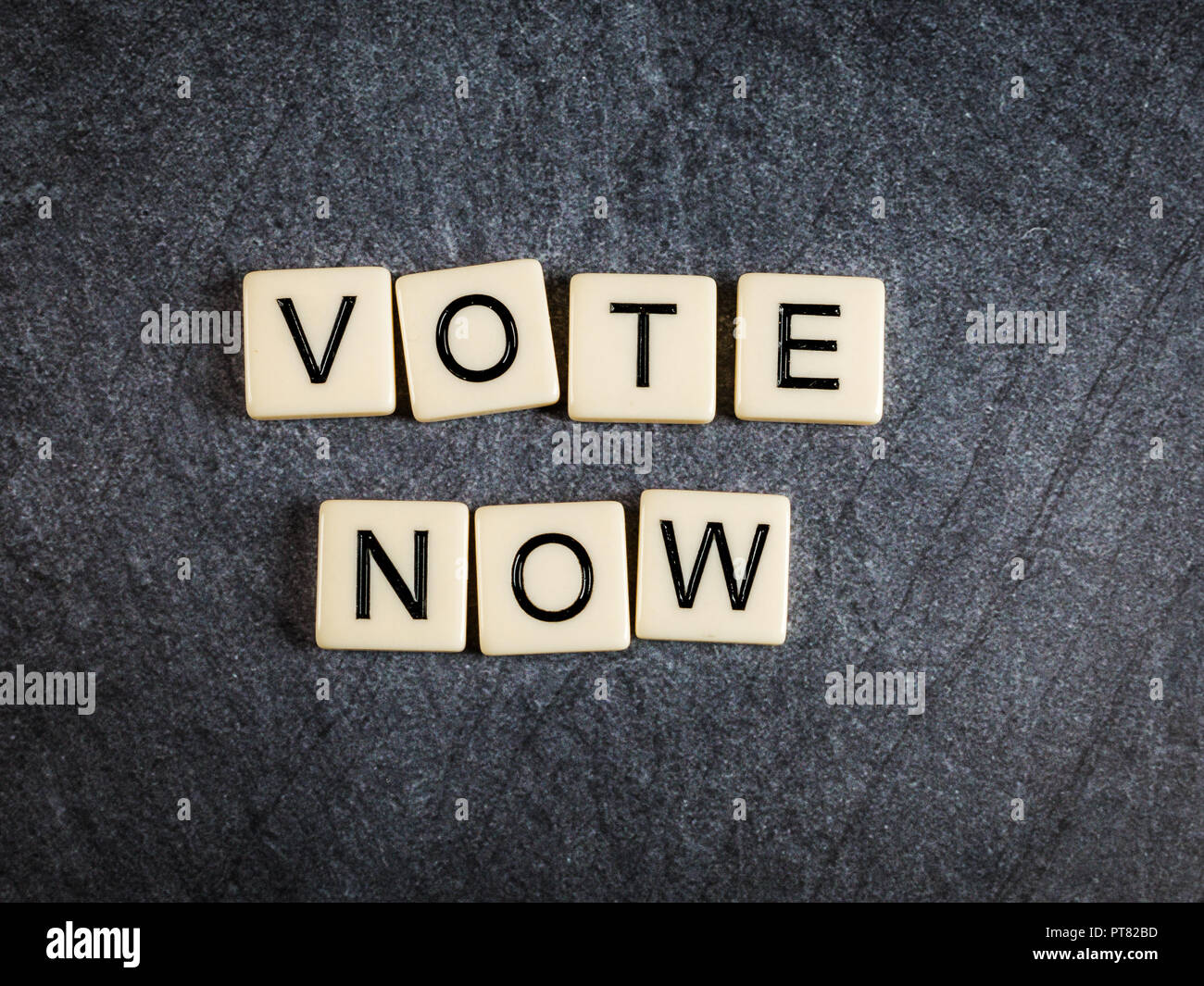 Letter tiles on black slate background spelling Vote Now Stock Photo ...
