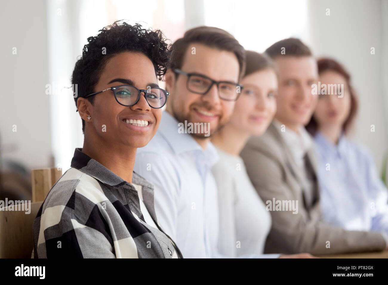 Happy multiracial team smiling looking at camera Stock Photo - Alamy
