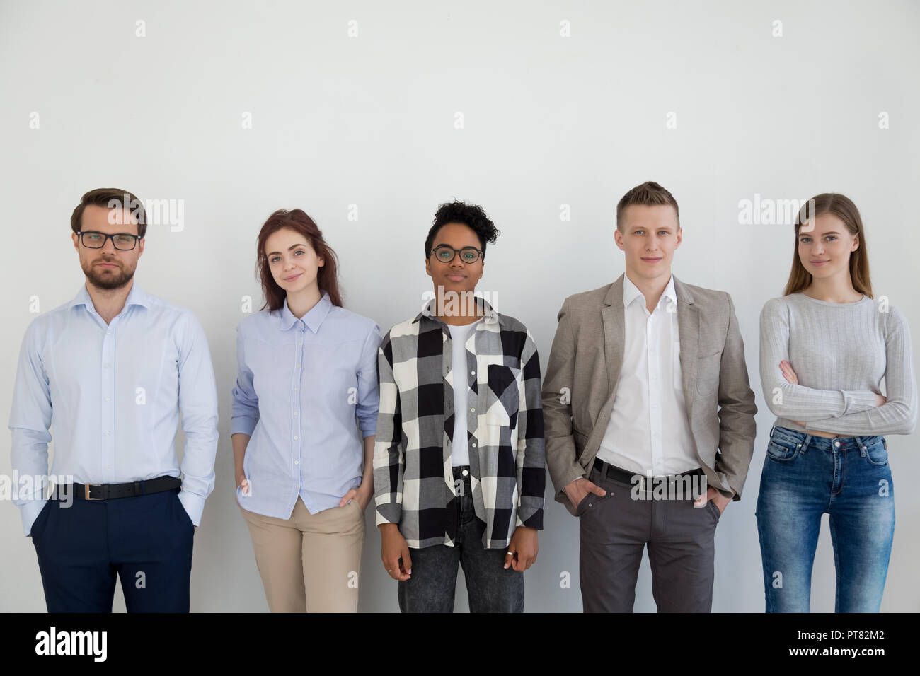 Group of young business people standing looking at camera Stock Photo ...