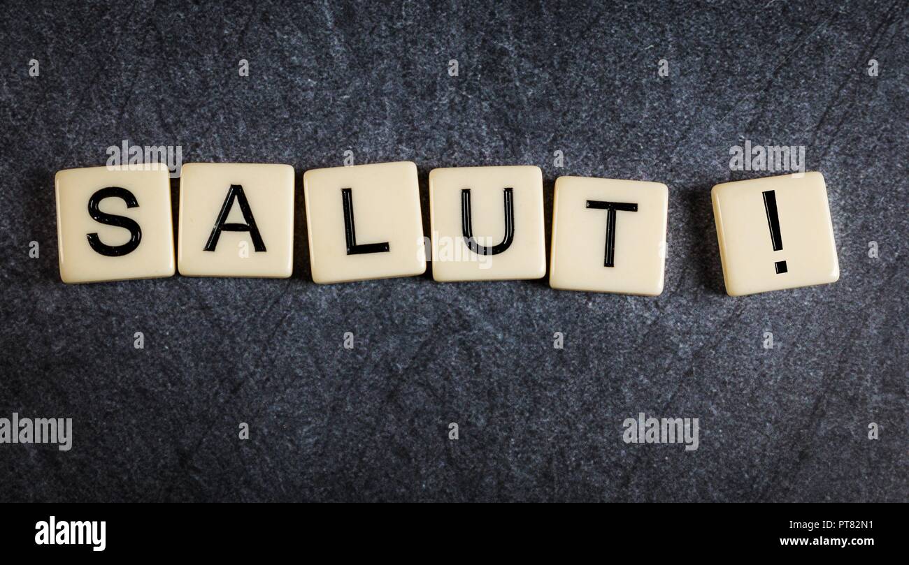 Letter tiles on black slate background spelling Salut! Stock Photo - Alamy