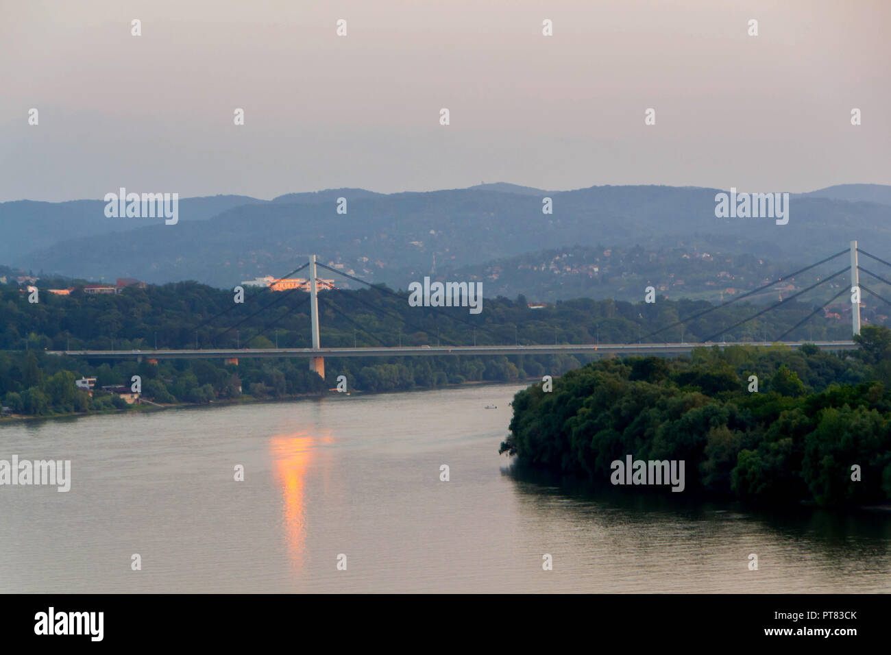 A bridge over the Danube with the Fruska Gora Mountain in the ...