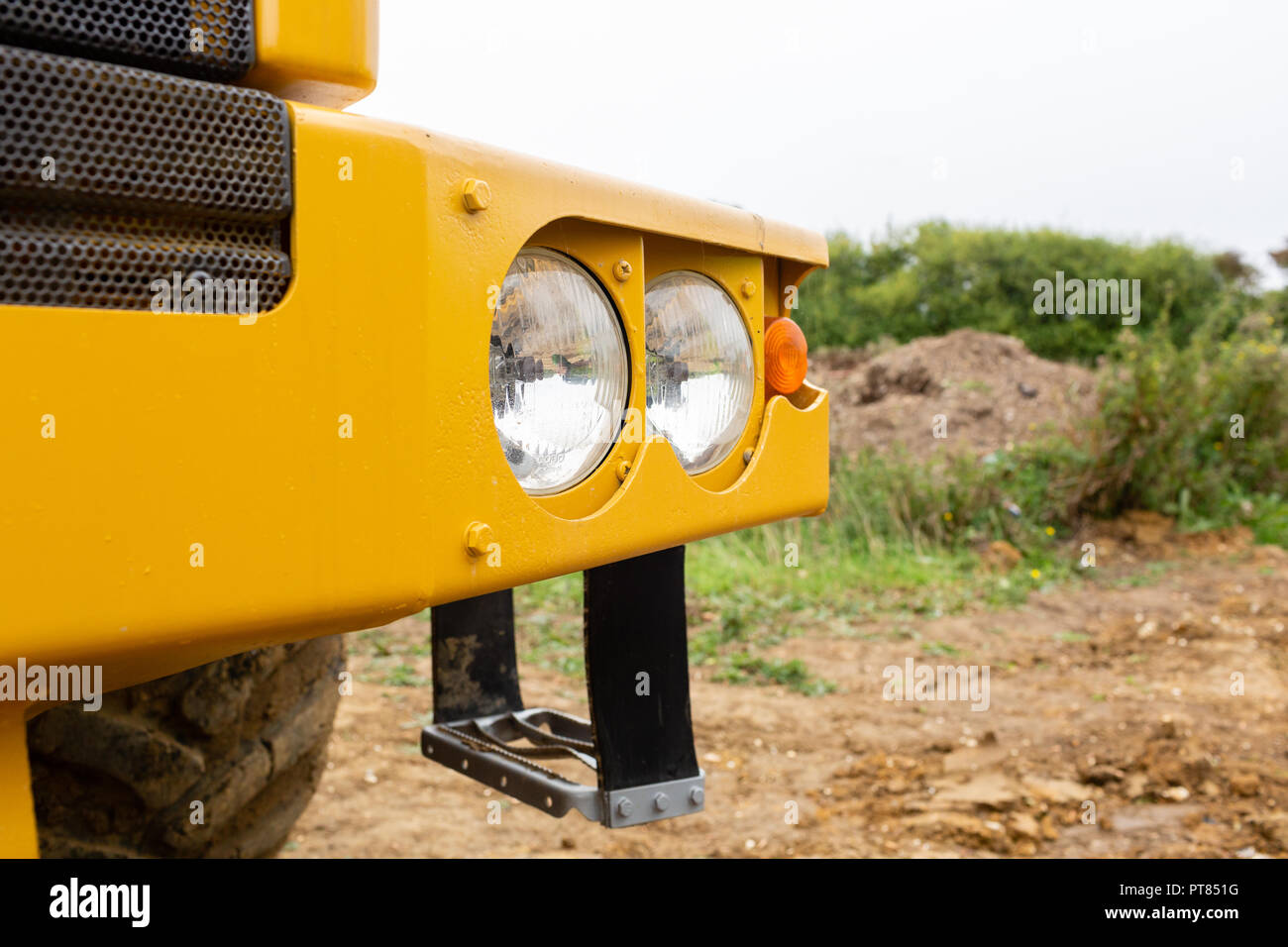 Front headlight of heavy machinery. Yellow body color Stock Photo - Alamy