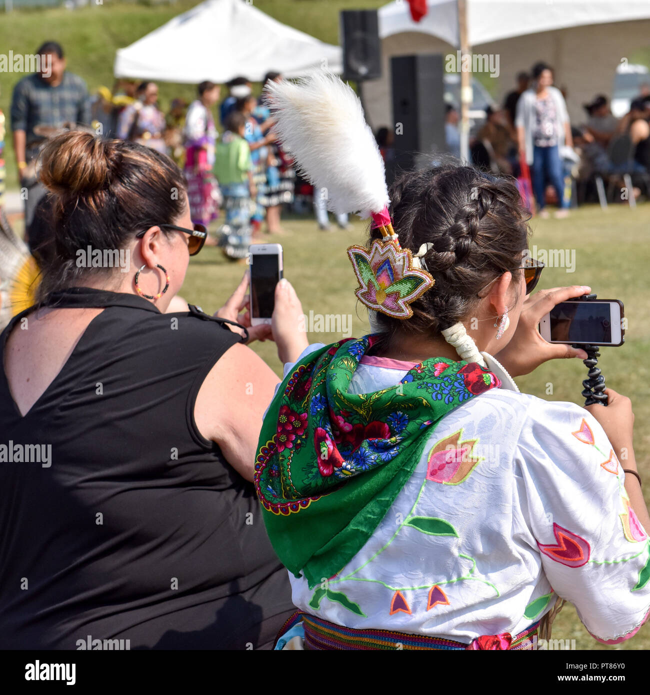 First Nations women taking photographs during Pow Wow celebration ...
