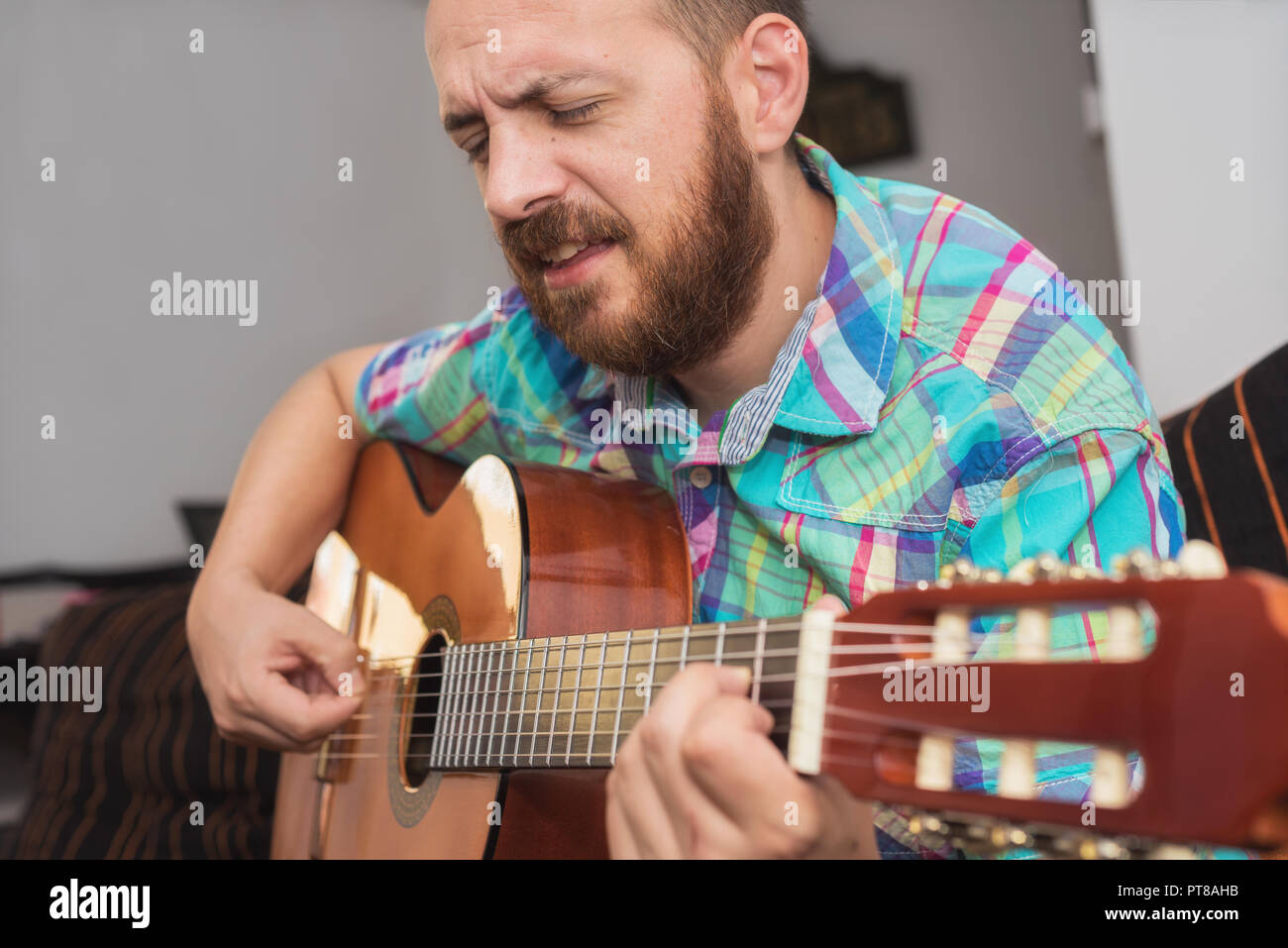 Young man musician playing acoustic guitar Stock Photo - Alamy