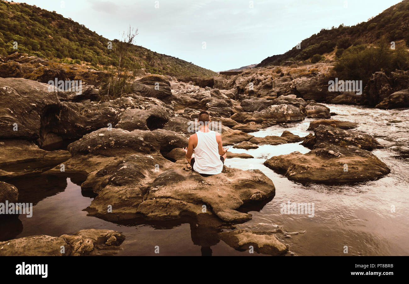 Young man sitting on the rocks hi-res stock photography and images - Alamy