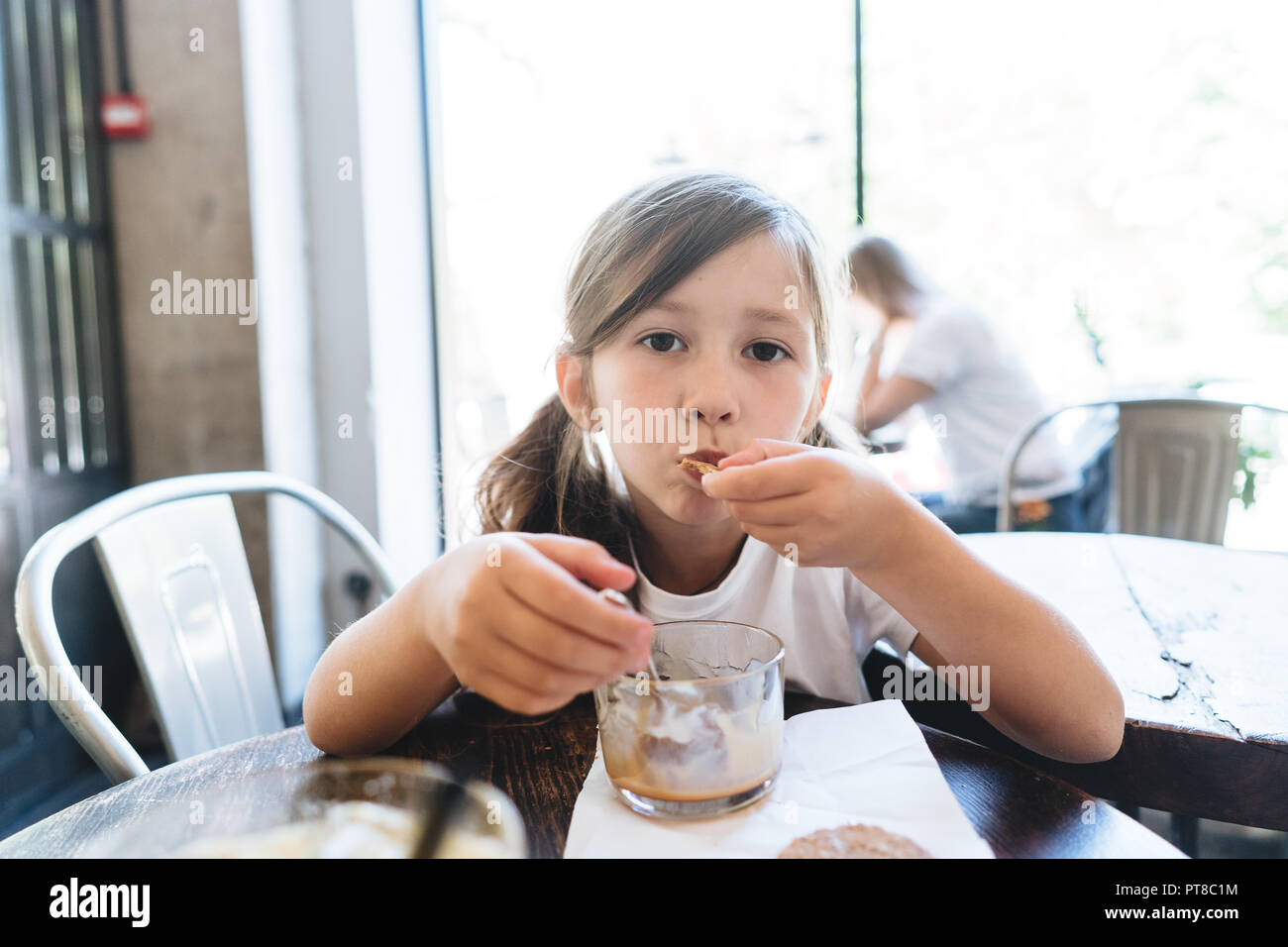 Teen girl is eating ice cream in a restaurant Stock Photo - Alamy