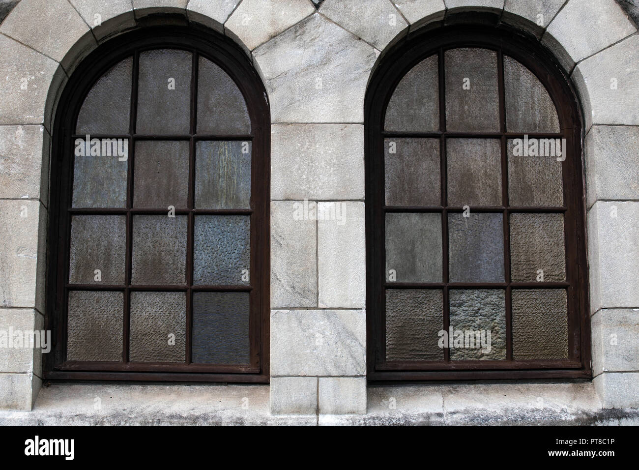 The old and ancient windows in stone wall of a castle, historical close ...