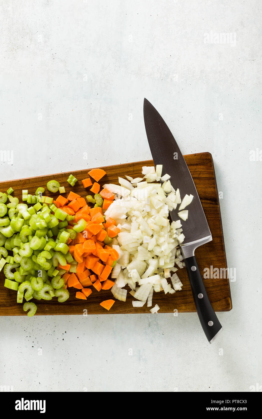chopped vegetables and a chef's knife on a wooden cutting board. Basic ...
