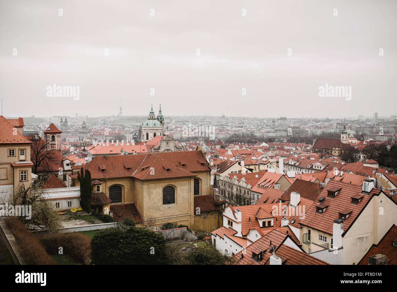 City of Prague with red roofs and Church in fog. City view of Praha old ...