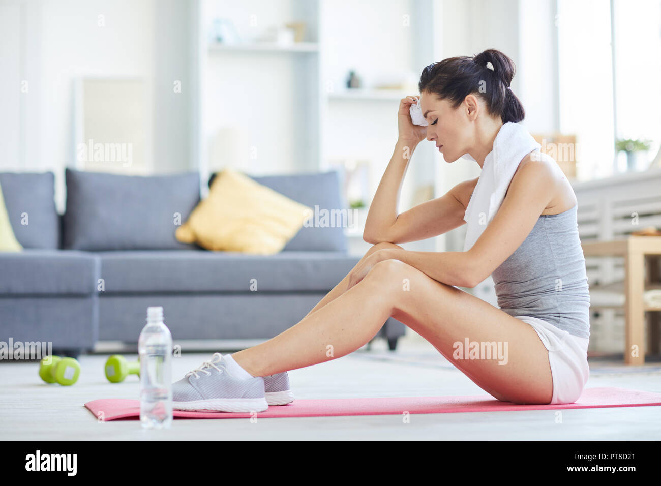 Active young woman with towel on her neck having rest after hard ...