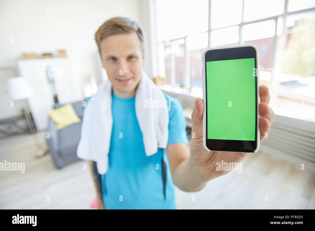Active young man showing curious pic or promo on touchscreen of ...