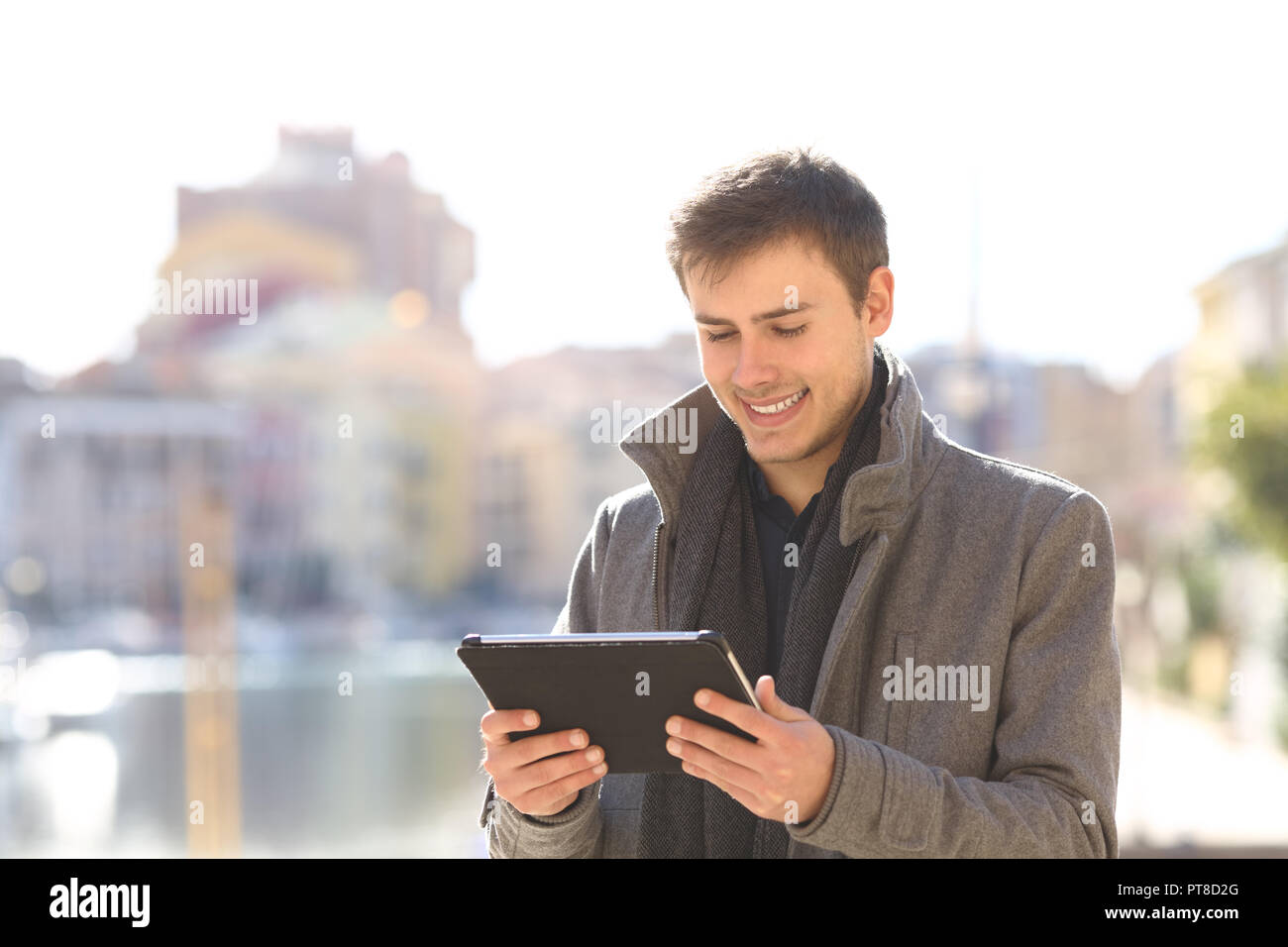 Happy man checking a tablet content in winter holiday Stock Photo - Alamy
