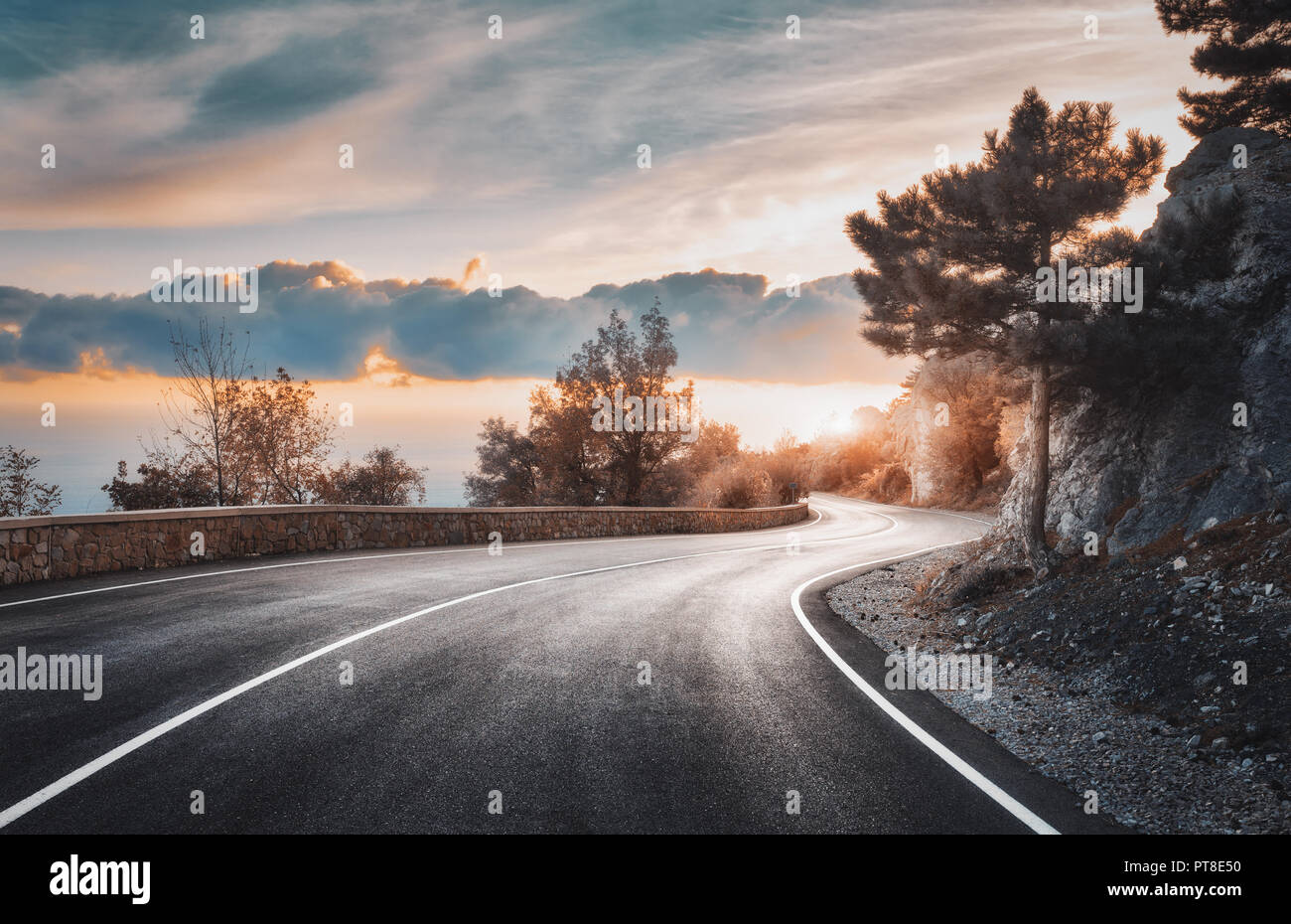 Mountain road at sunset. Landscape with rocks, sky with clouds and ...