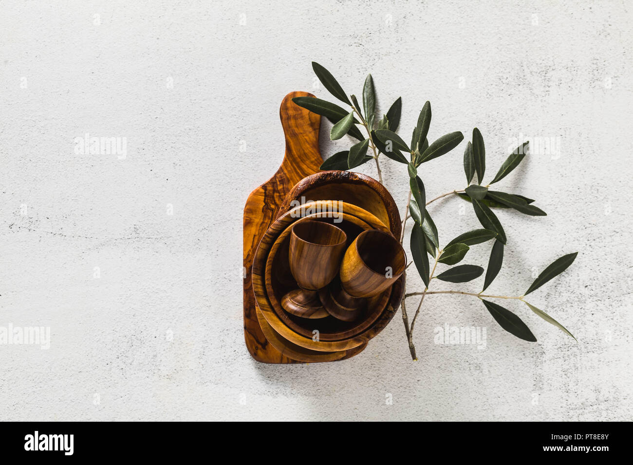 wooden utensils from the olive tree on the white kitchen table and the ...