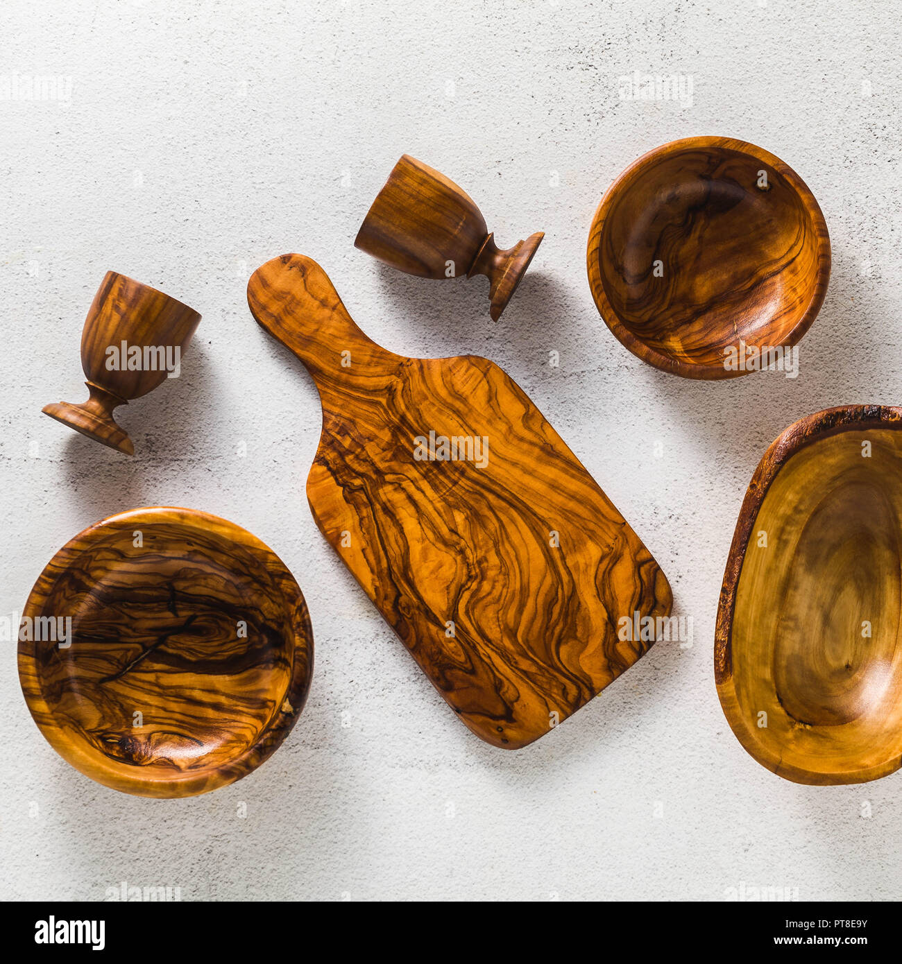 wooden utensils from the olive tree on the white kitchen table and the ...
