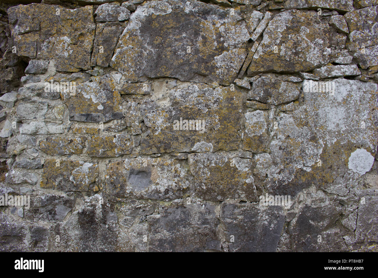 Old gray deteriorating medieval stone wall background with ...