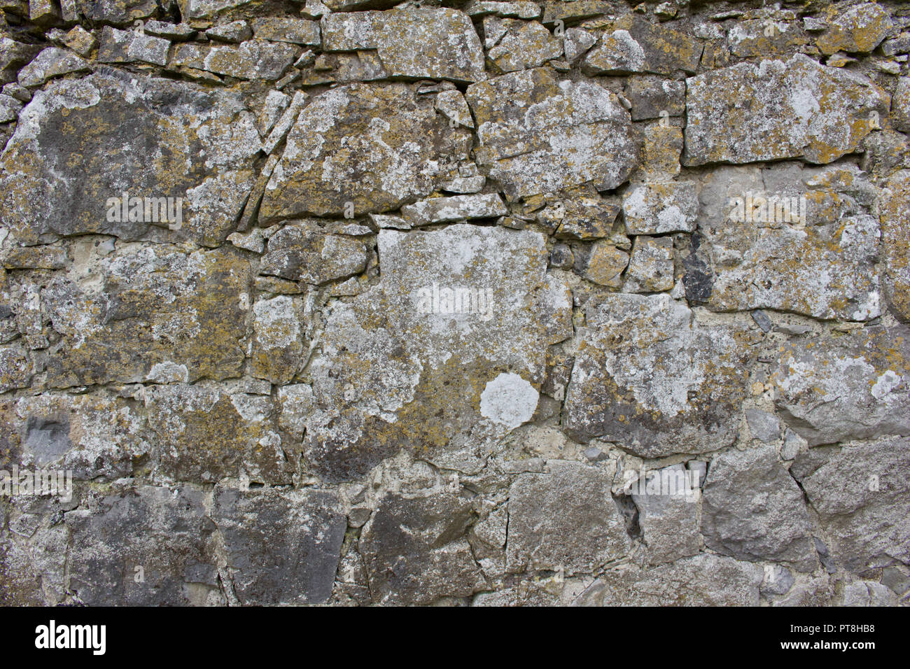 Old gray deteriorating medieval stone wall background with ...