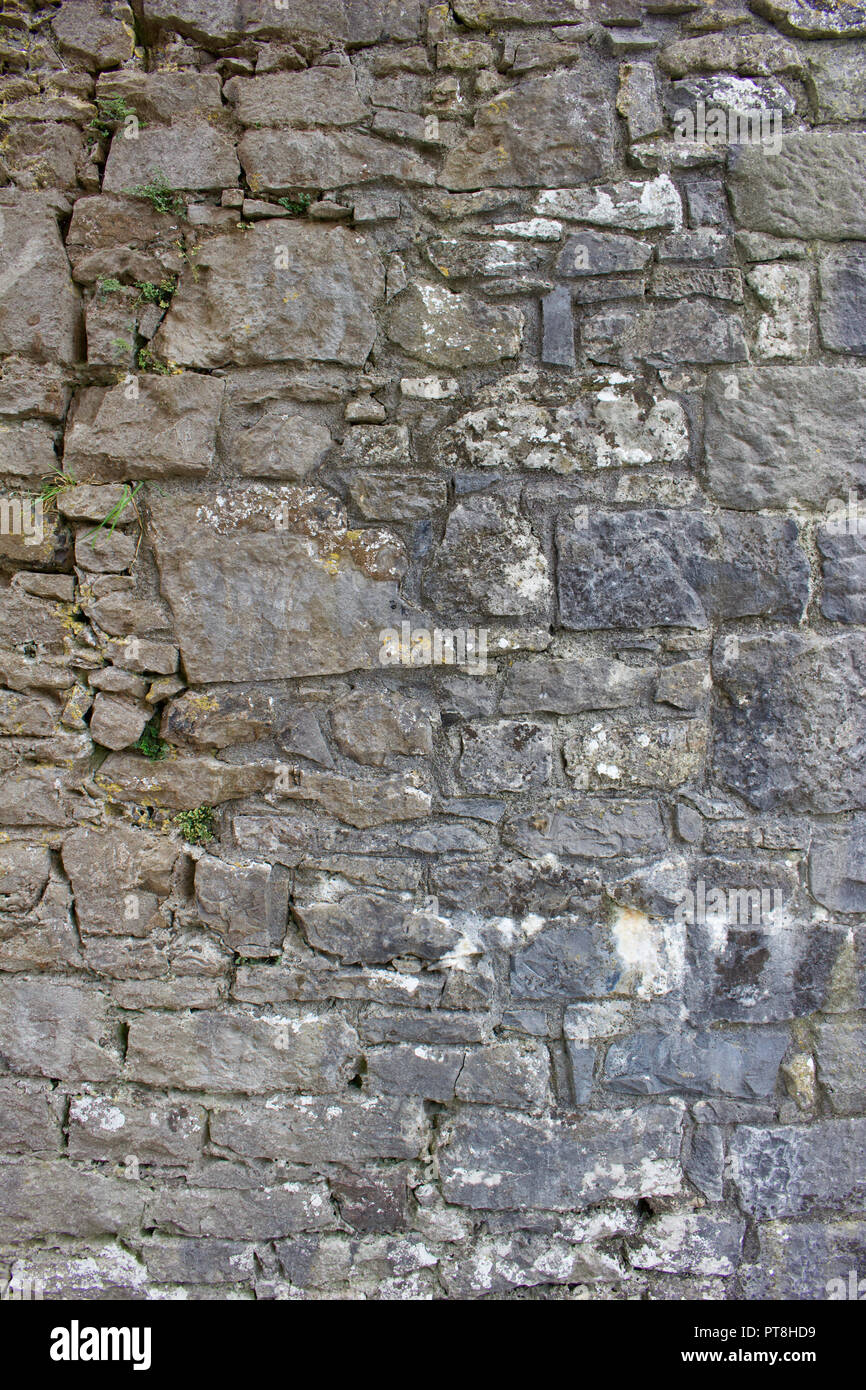 Old gray deteriorating medieval stone wall background with ...