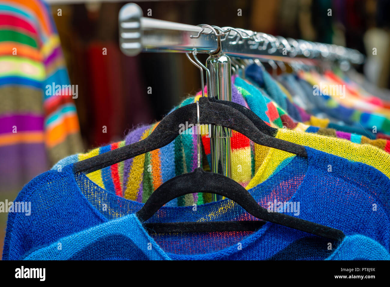 Colorful clothes hang on shelf in a market Stock Photo - Alamy