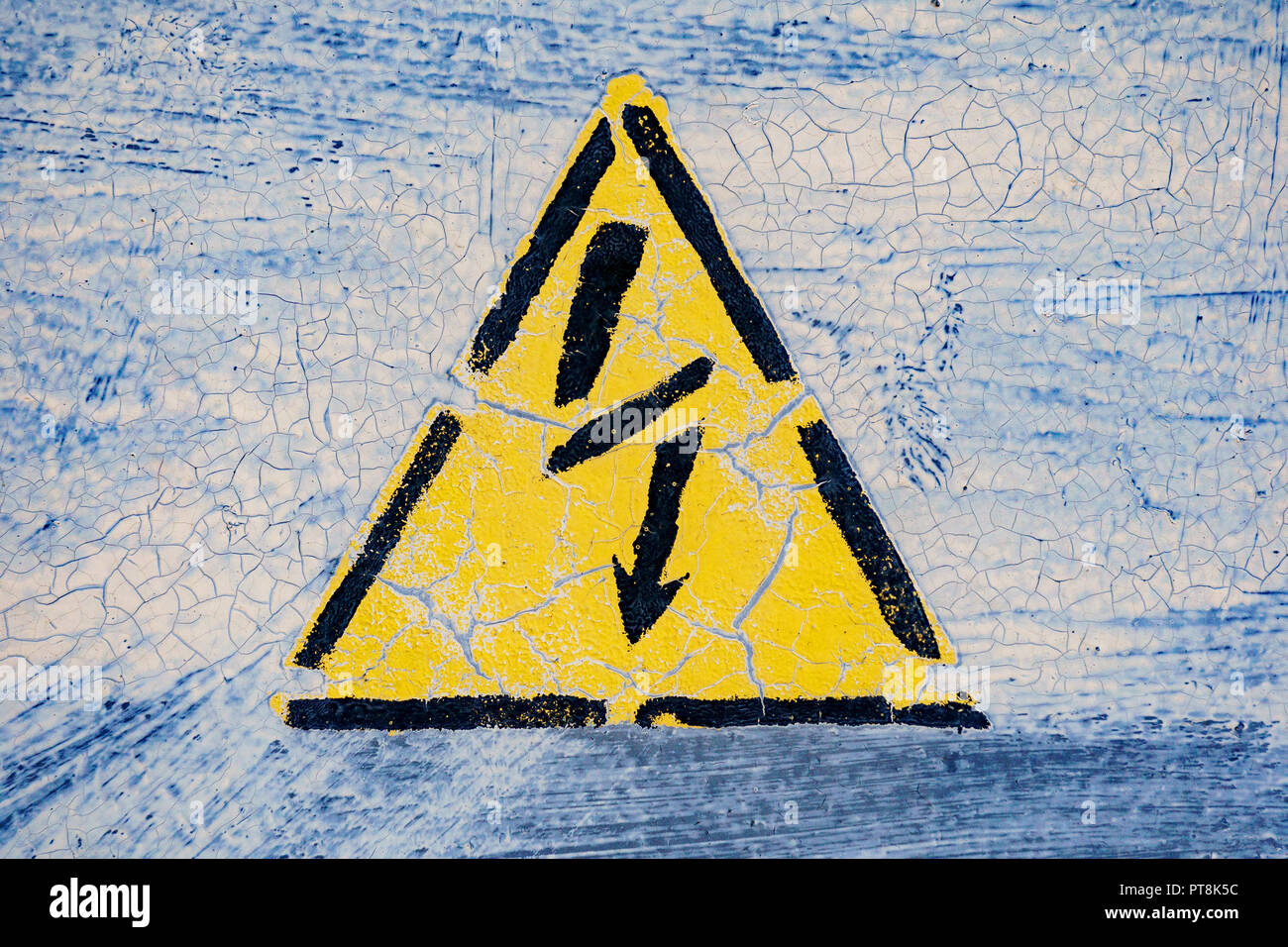Old risk of electric shock triangle sign on light grey weathered ...