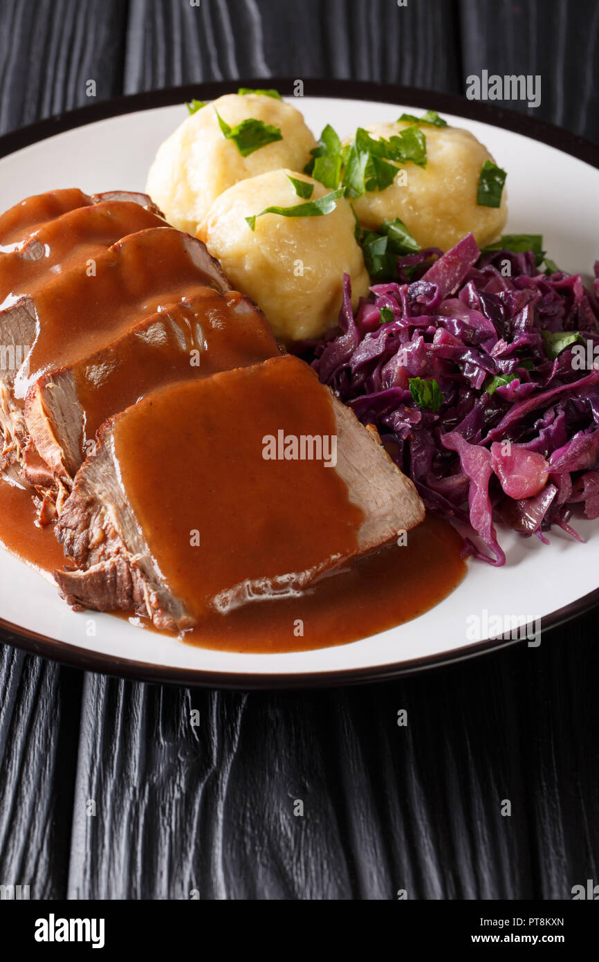 Traditional Sauerbraten dish with potato dumplings and red cabbage ...