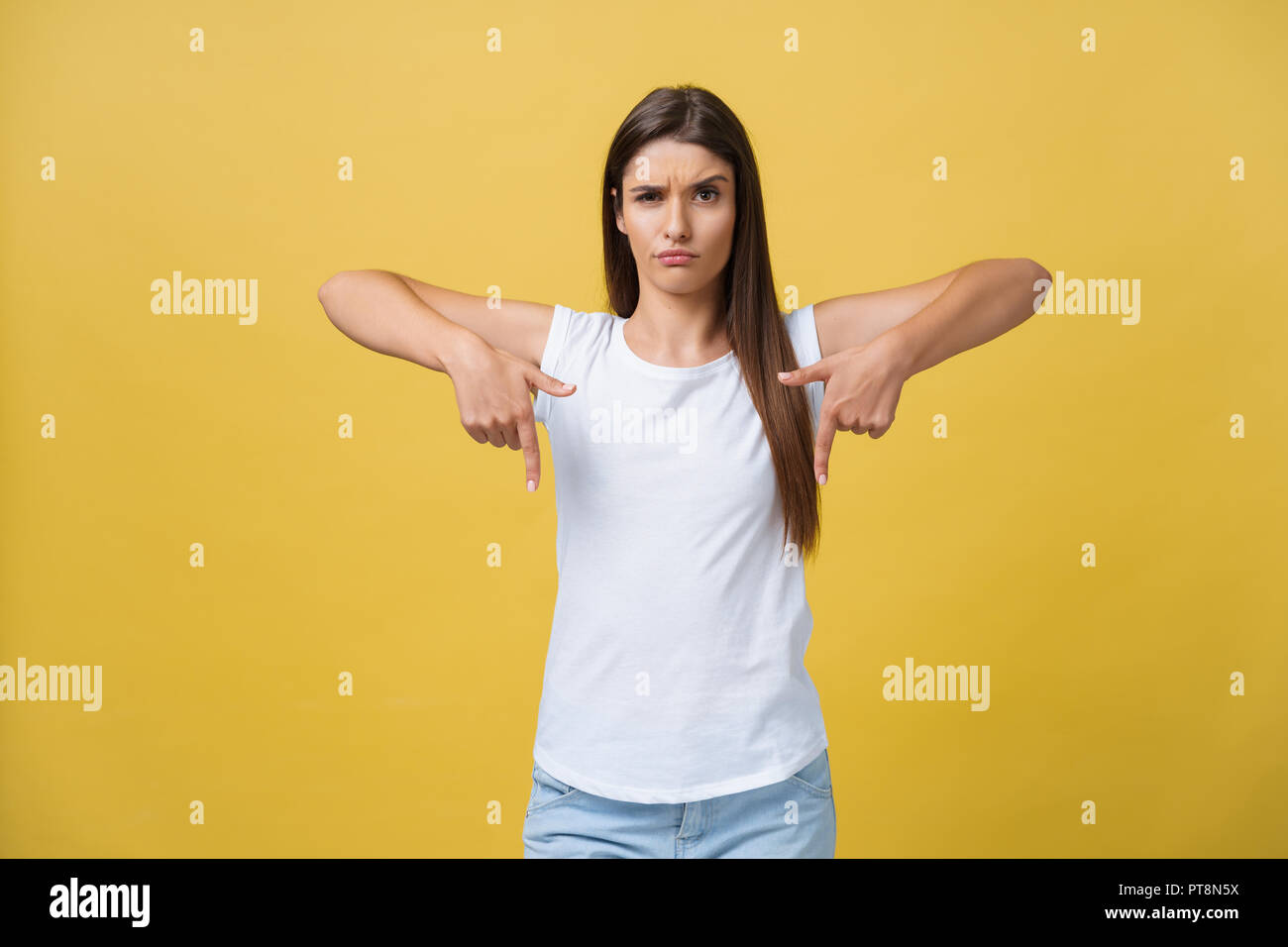 Closeup portrait of young pretty unhappy, serious woman pointing at ...