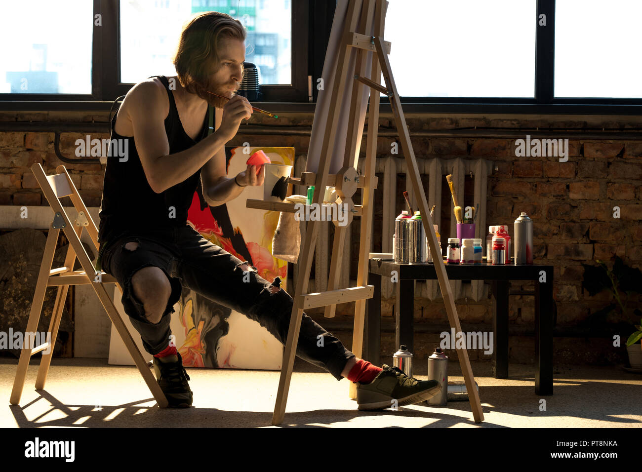 Full length side view portrait of handsome male artist painting on ...