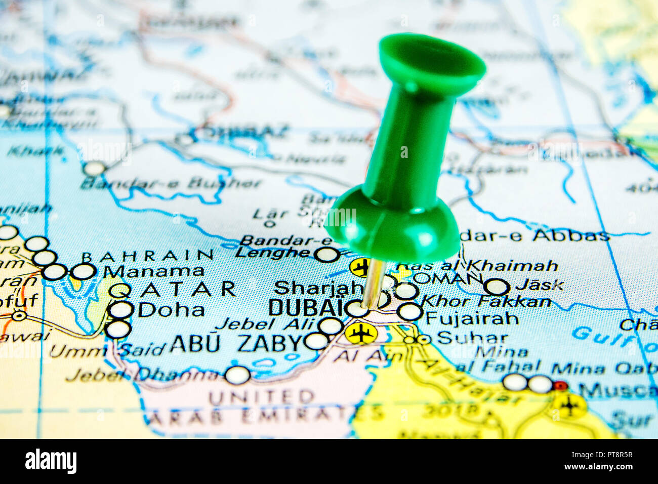closeup of draw-pin stick into real map, travelling to Dubai ...