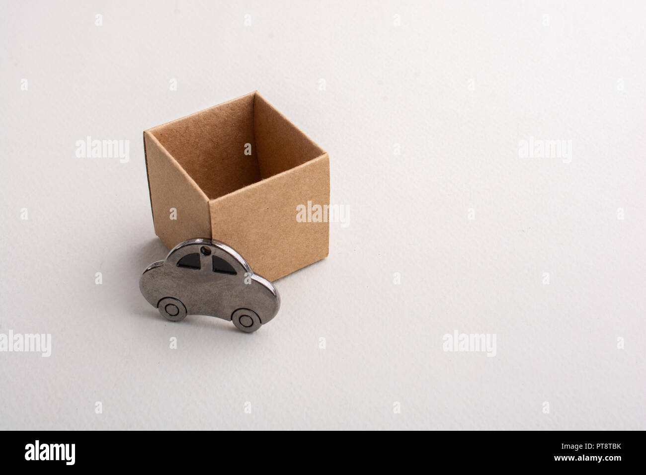 Little car model beside a box on white background Stock Photo - Alamy