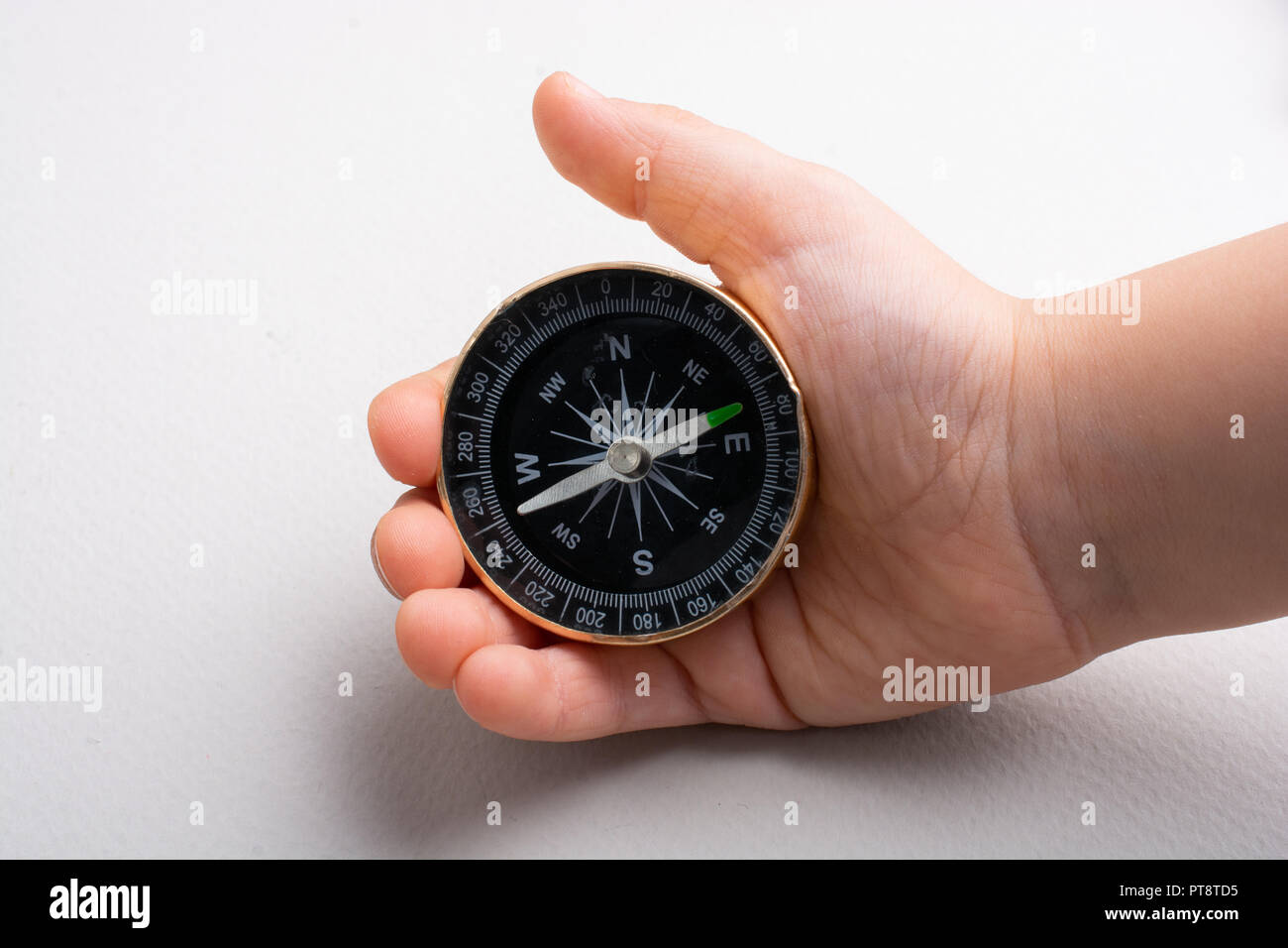 Compass tool in toddler hand on white Stock Photo - Alamy