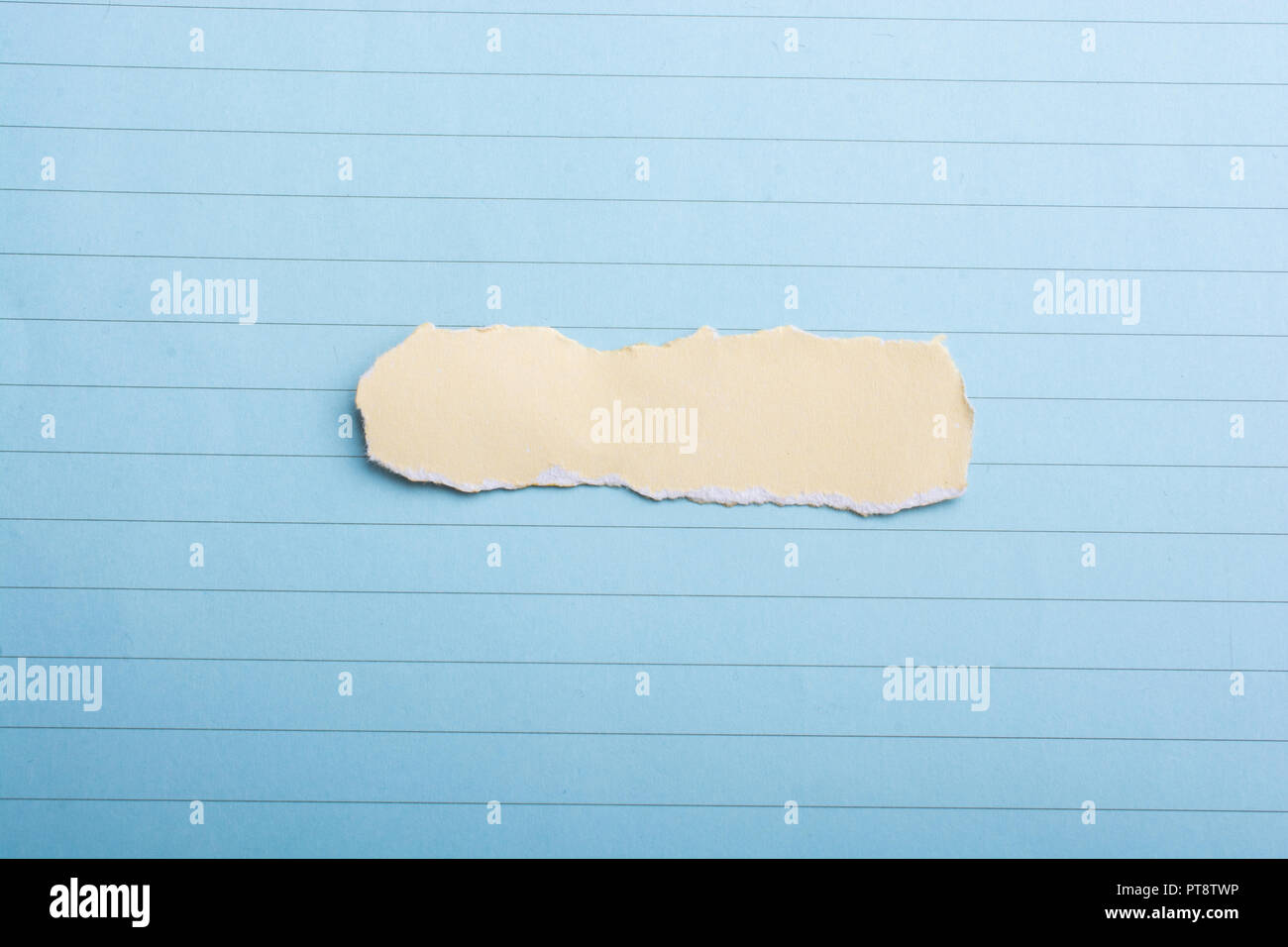 Little torn paper seen on a sheet of paper Stock Photo - Alamy