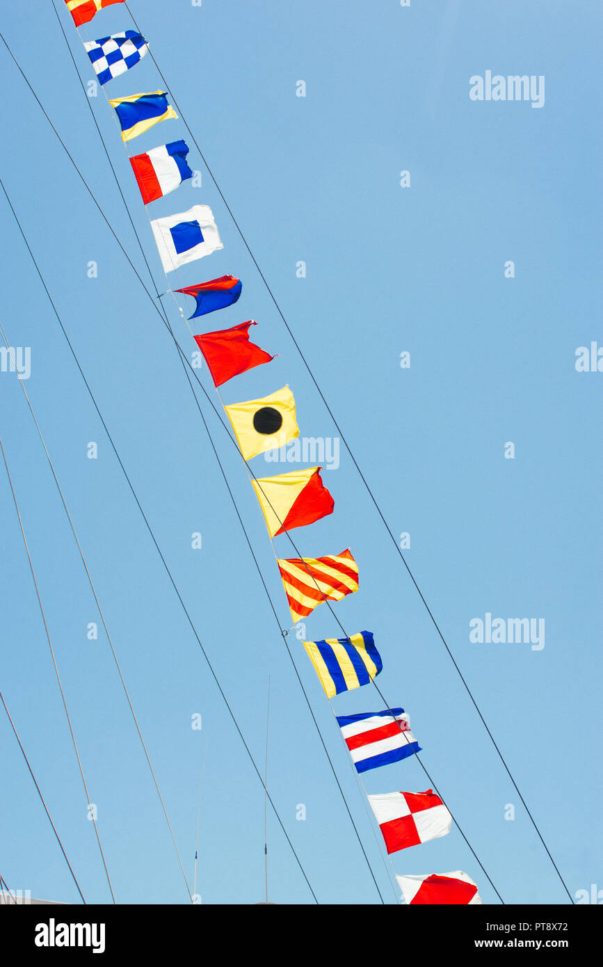 Colorful nautical sailing flags flying in the wind from the lines of a ...