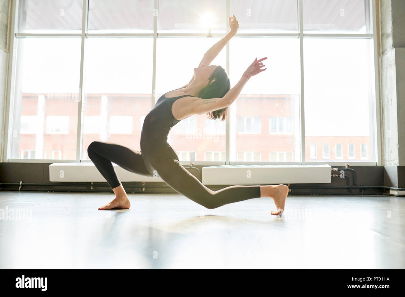 Full length portrait of contemporary young woman dancing passionately ...